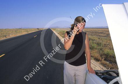 Stranded woman using a cell phone to call for help. | David R. Frazier ...
