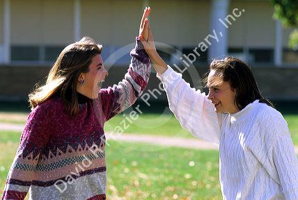 Teen girls giving eachother a high five. | David R. Frazier ...